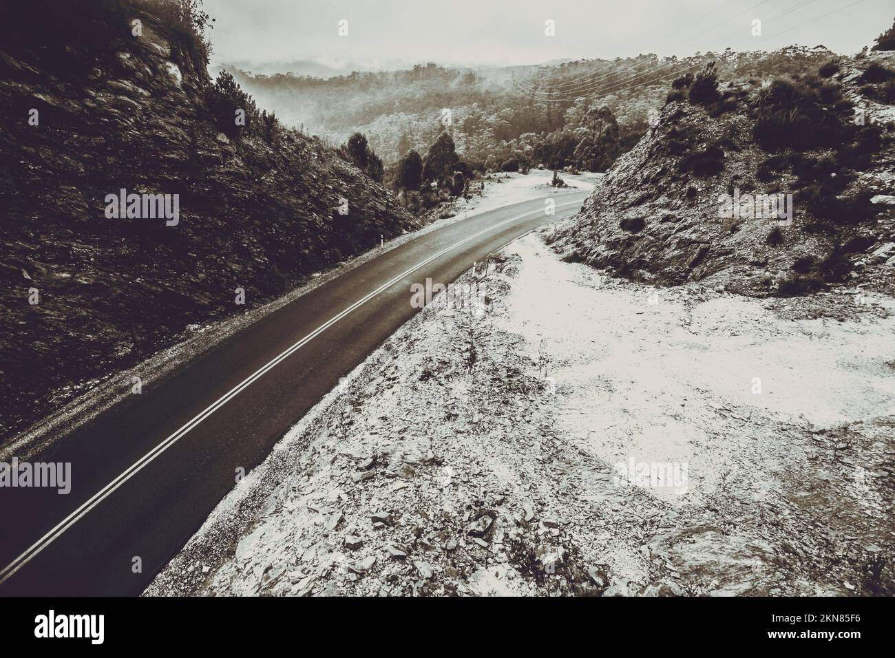 Dramatic winter landscape on a fog covered steep road touring around ...