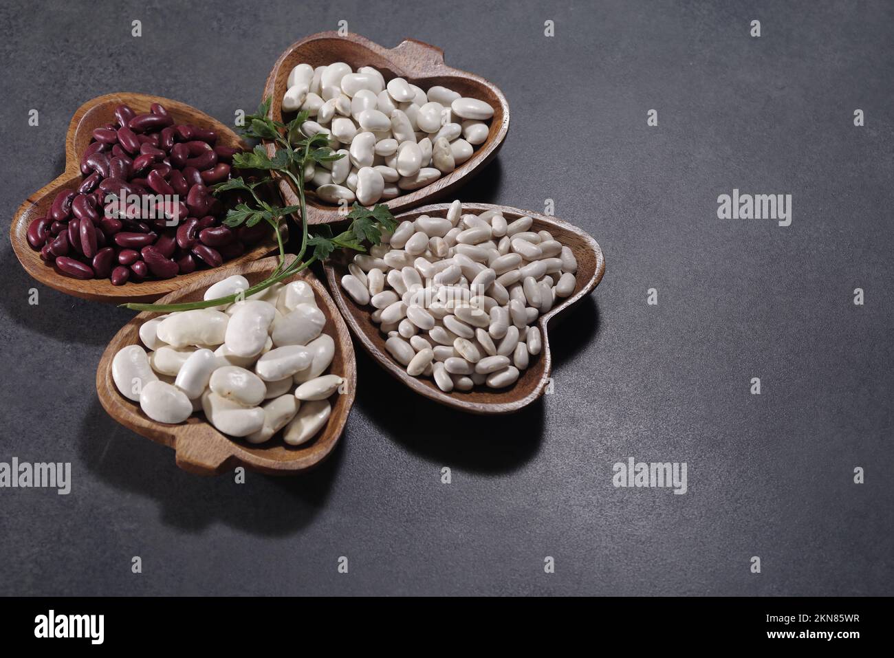 Healthy raw dried large and small white beans on a wooden dish on a ...
