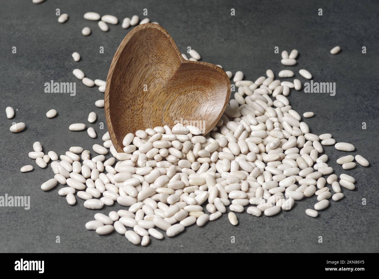 Healthy raw dried large and small white beans on a wooden dish on a ...