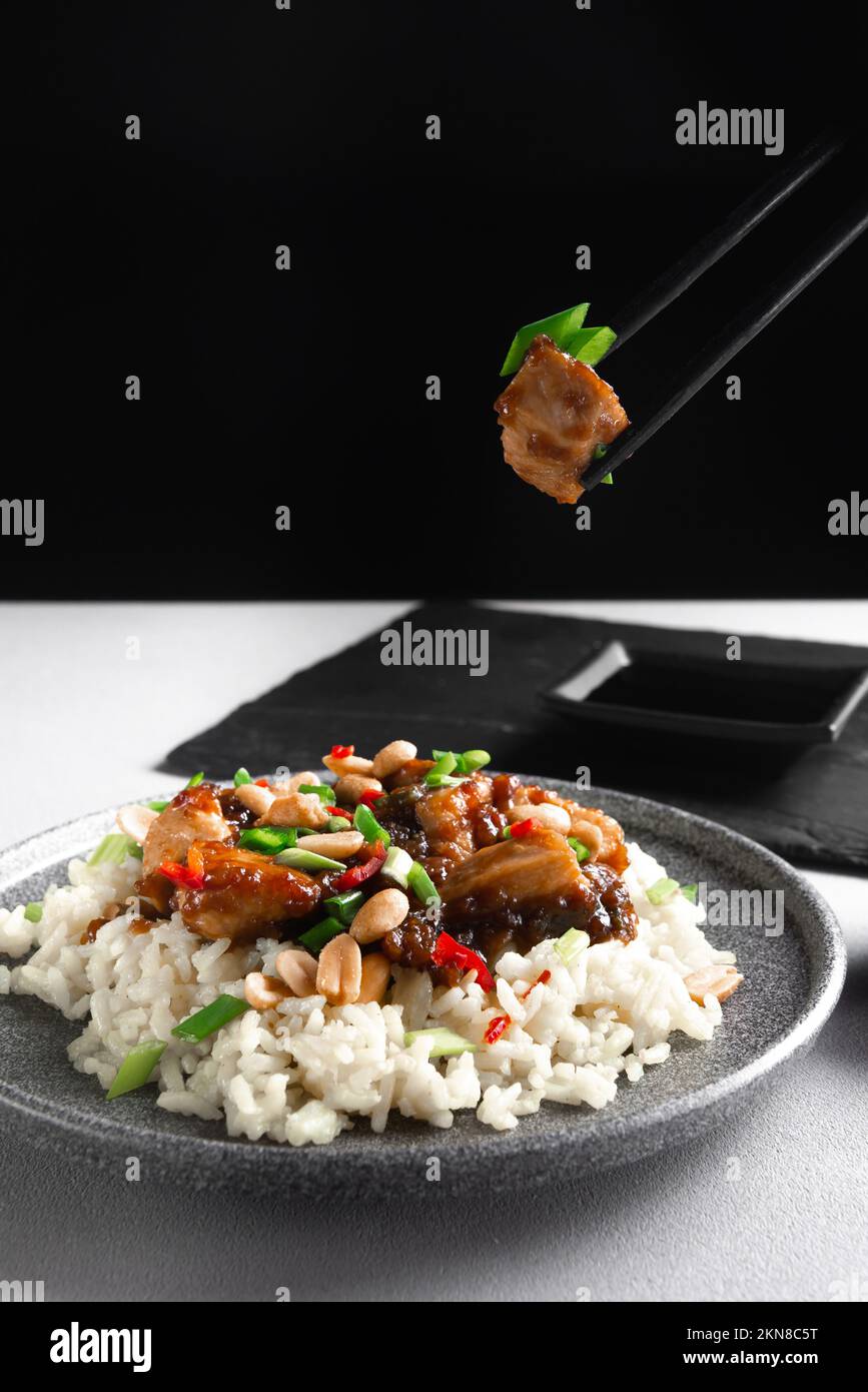 Asian cuisine. A woman's hand holds Asian food sticks. Rice with ...