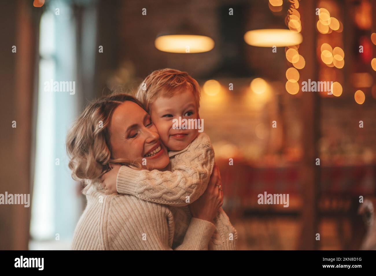 Portrait of happy family mom with small son in knitted beige sweaters ...