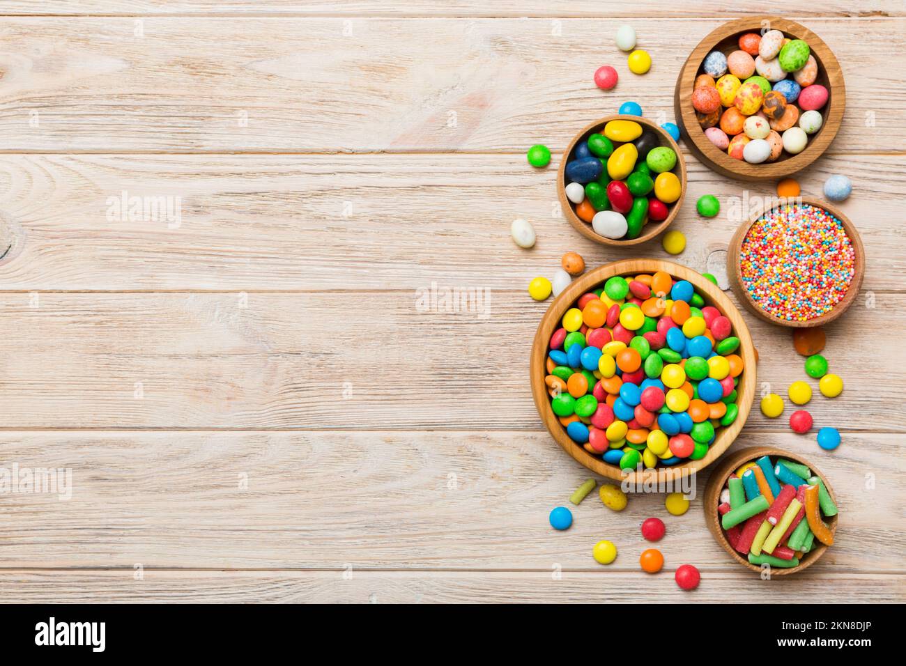 different colored round candy in bowl and jars. Top view of large ...