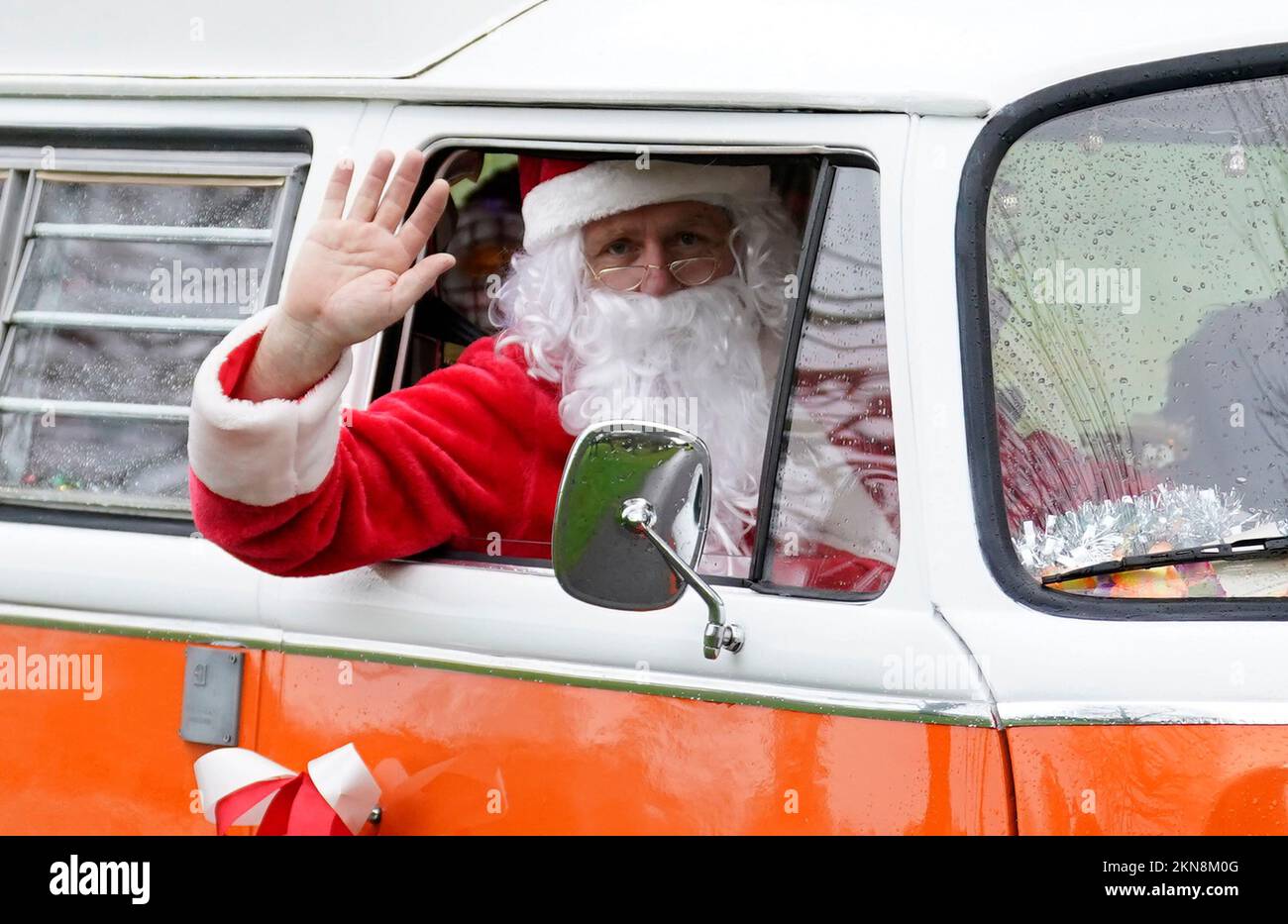 A participant dressed as Father Christmas waves from their VW Camper ...