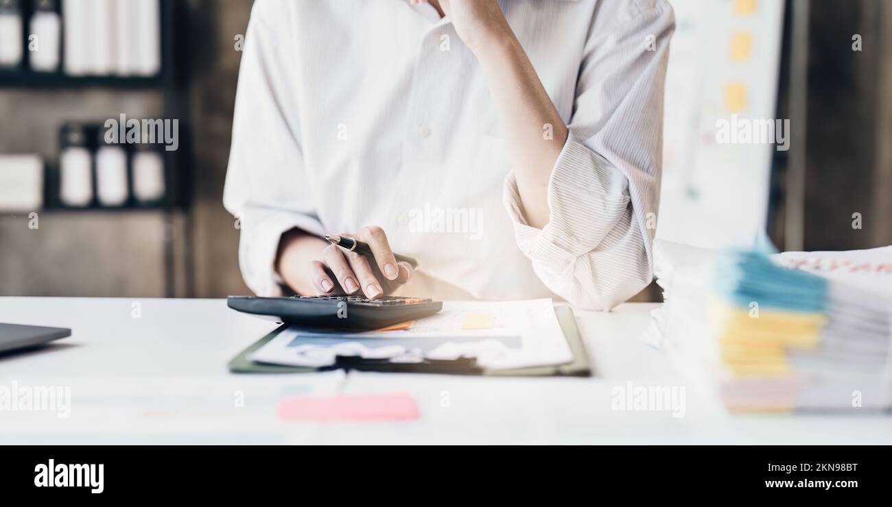 Asian Business woman working at home office and analyze financial ...