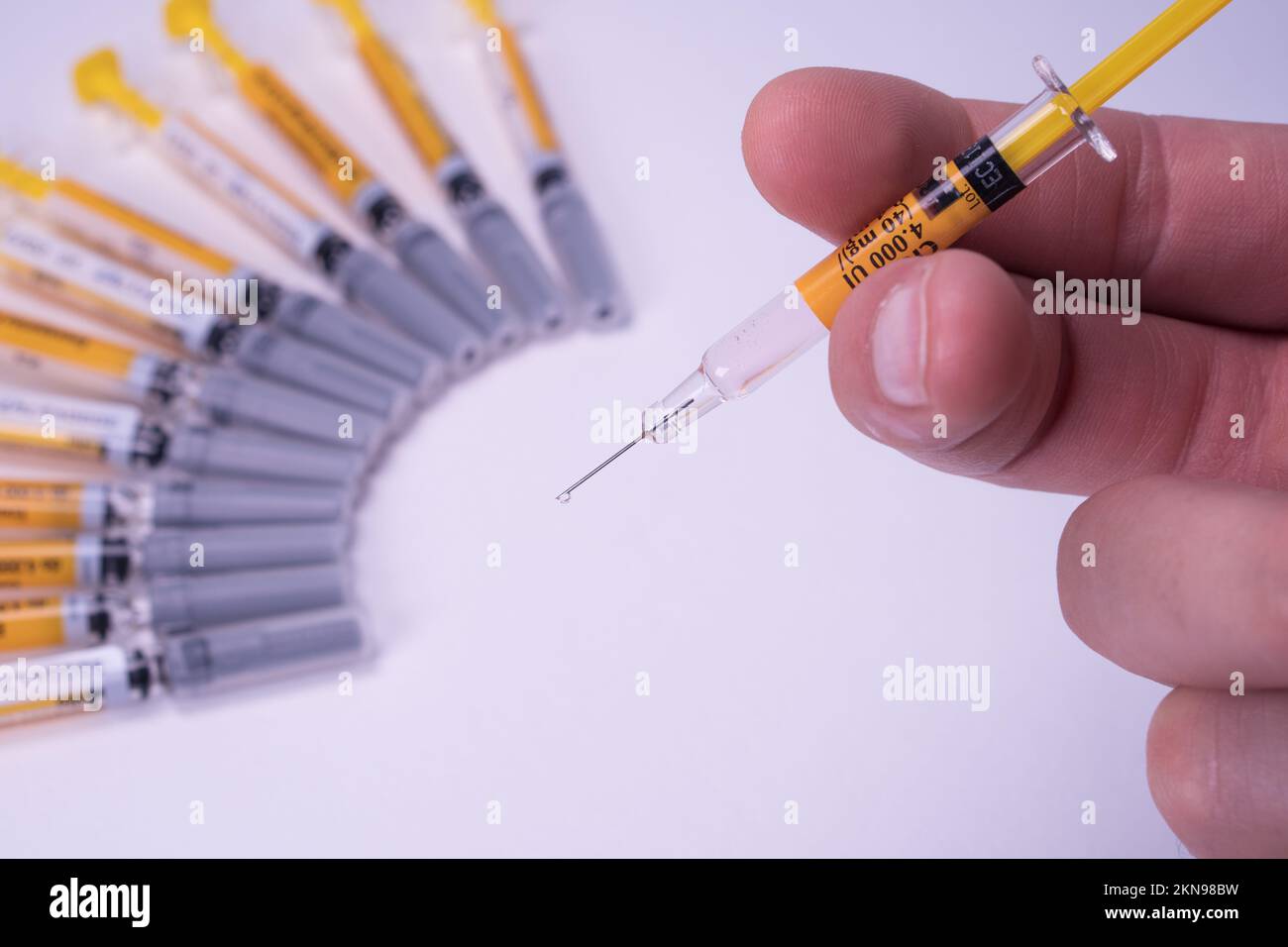 A person holding a syringe with pink liquid in a laboratory on an ...