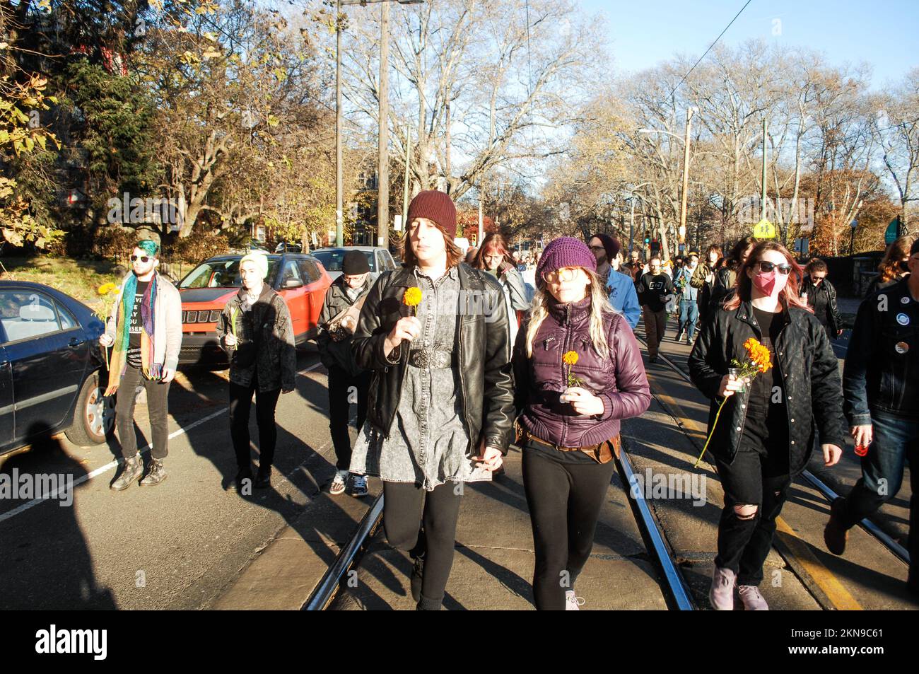 A couple holds hands as they carry flowers for the Q Nightclub mass ...