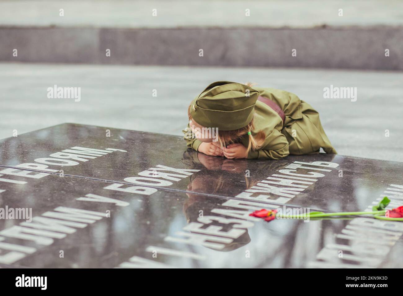 baby in Soviet military uniform leaned against the World War II stele ...