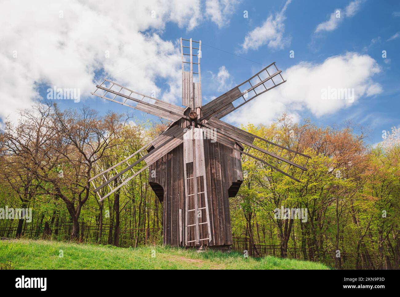 Antique wooden windmill on a hill near the forest. rural landscape ...