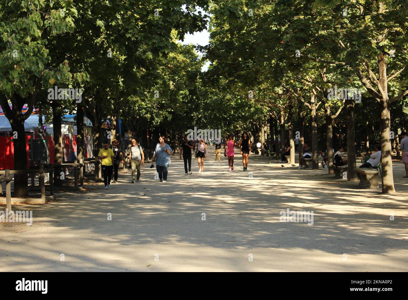 Locals and tourists in a corridor in Tuileries Garden enjoying the ...