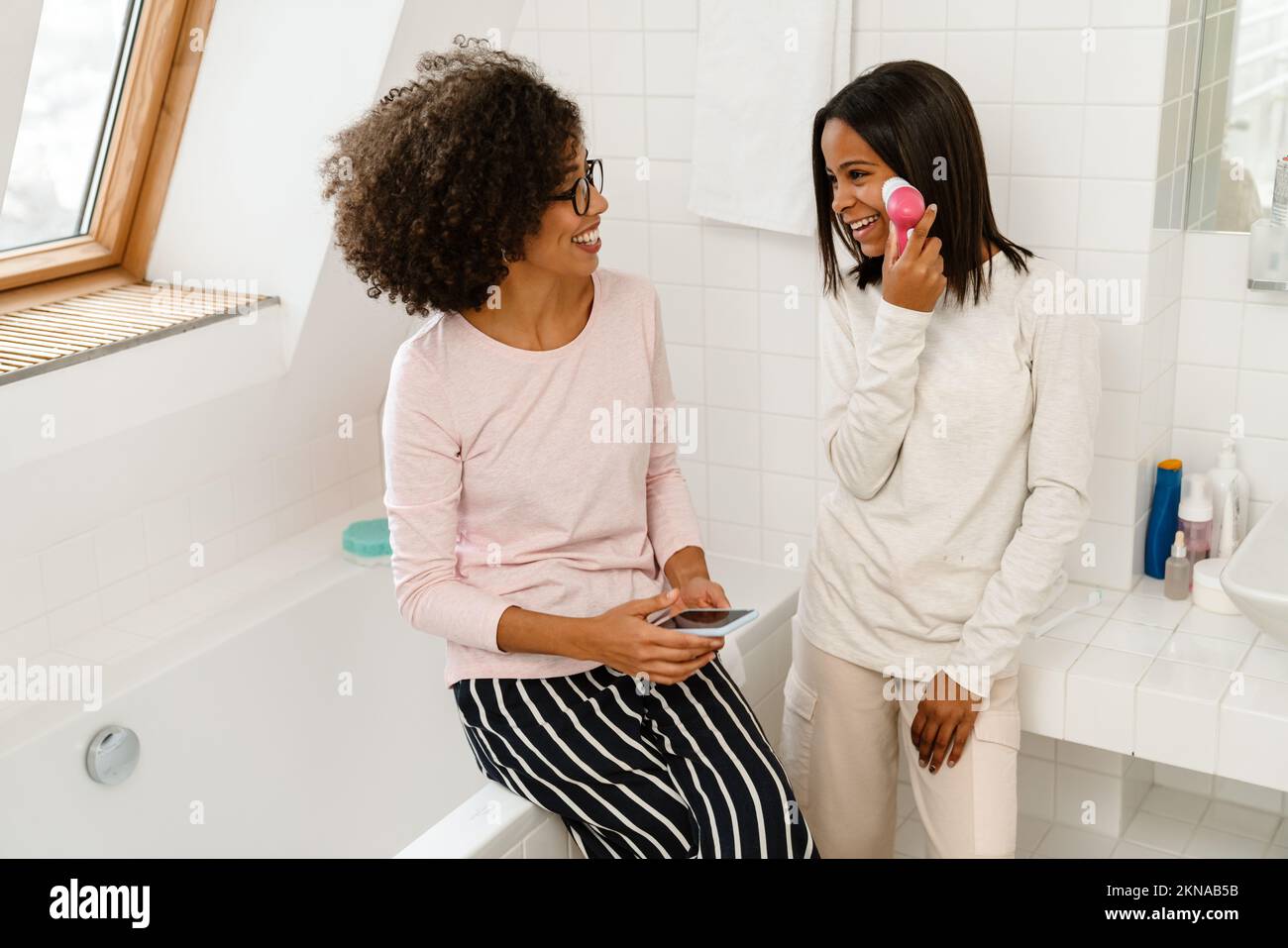 Happy african american woman and her teenage daughter doing beauty ...
