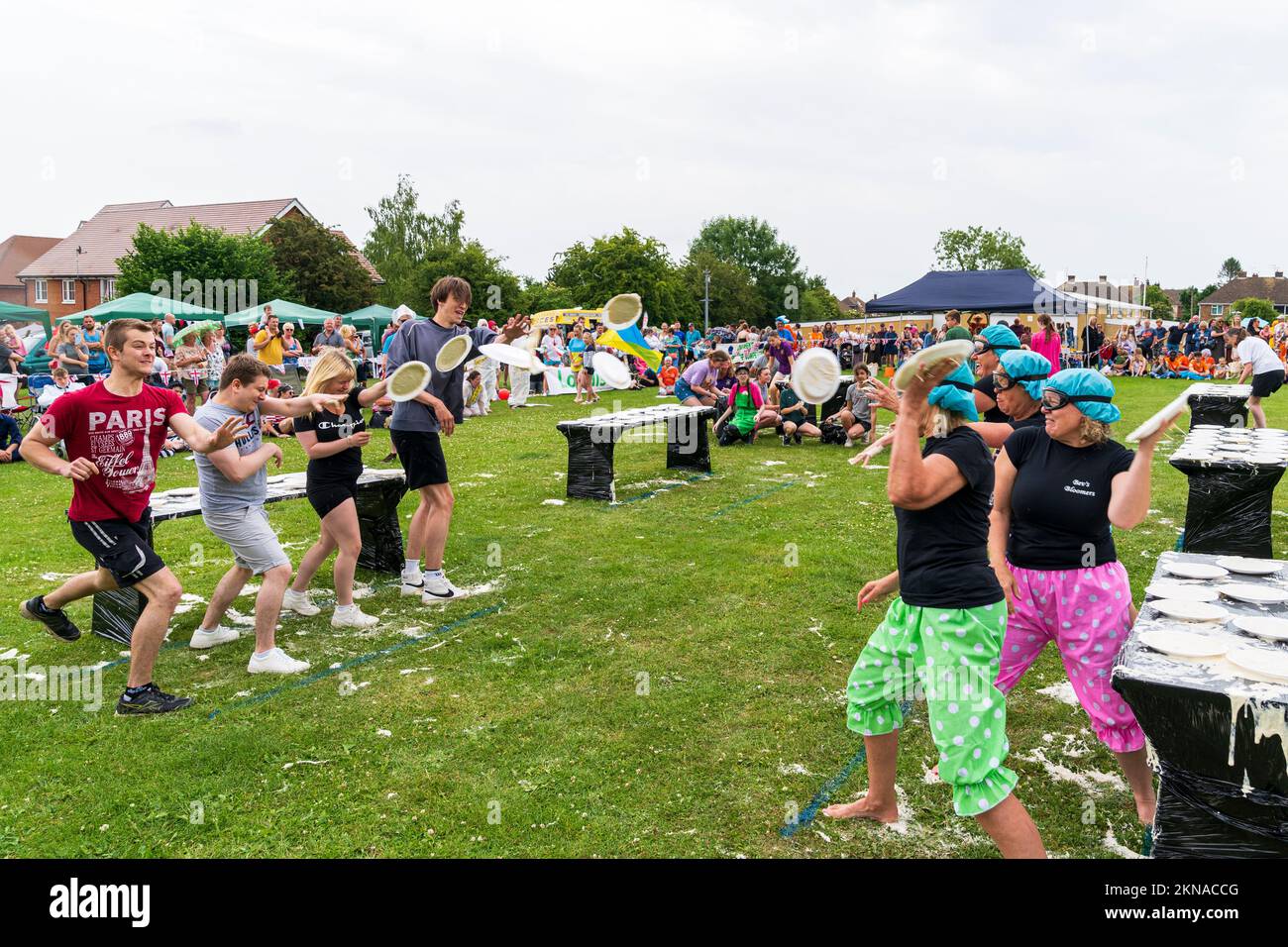 Two teams of four people throwing custard pies at each other at the ...