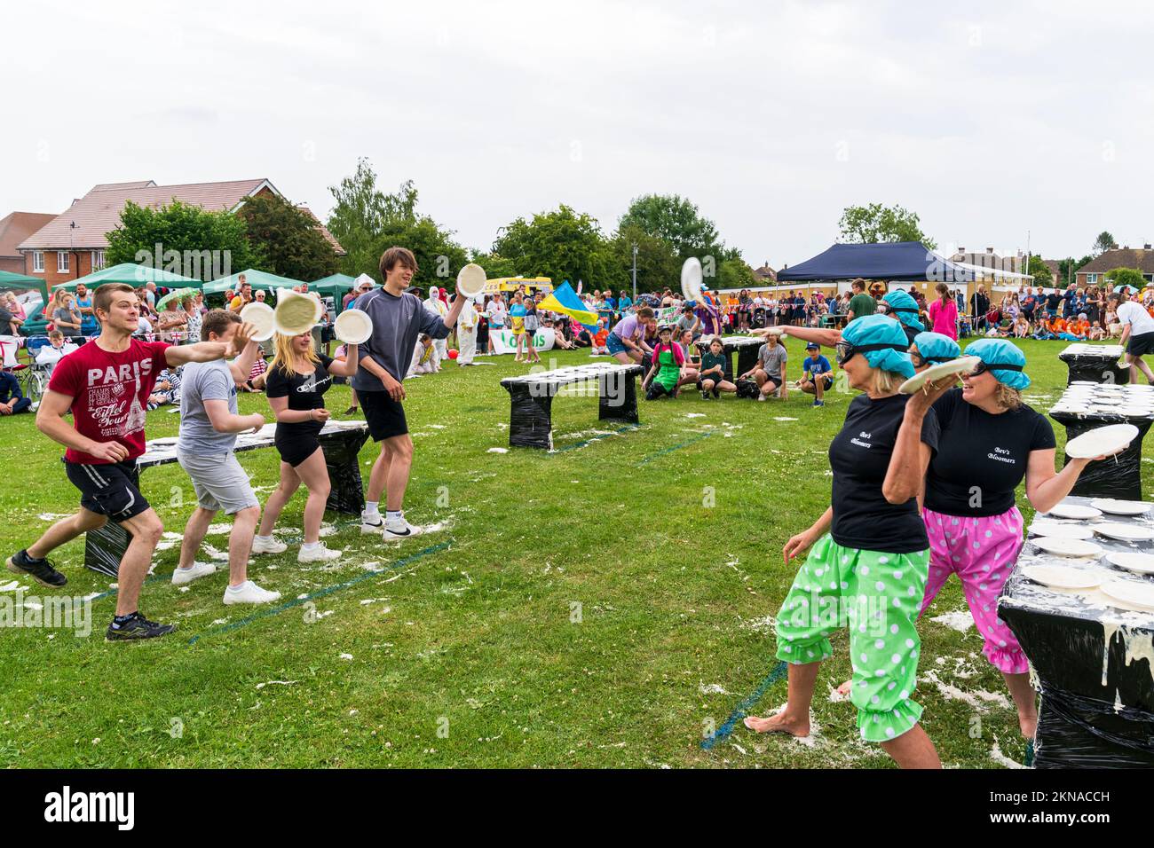 Two teams of four people throwing custard pies at each other at the ...