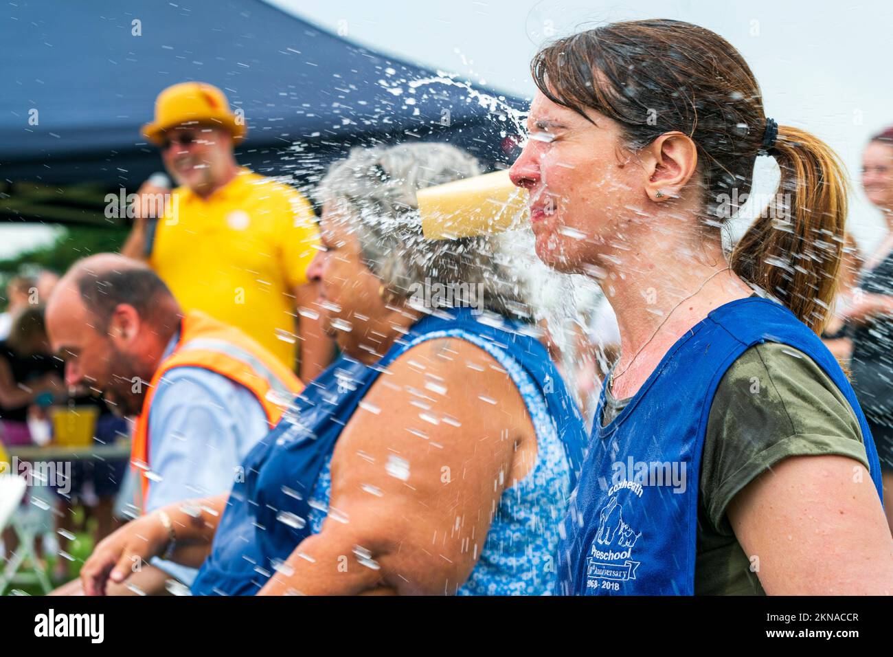 Close up of a woman being hit by a wet sponge on her chin, her eyes ...