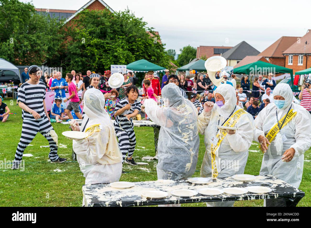 Two teams of four people throwing custard pies at each other at the ...