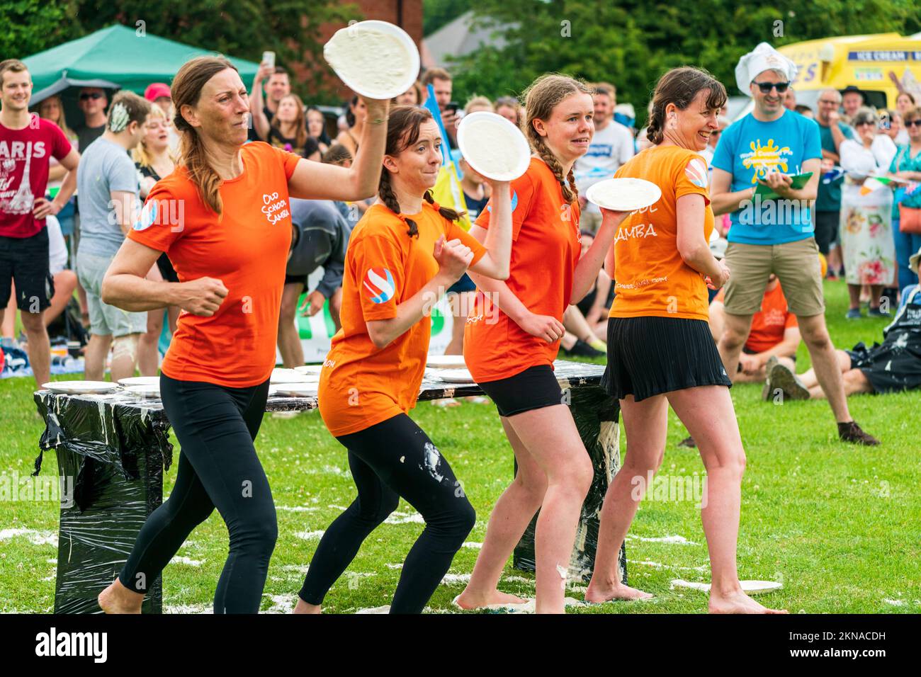 A team of four young women throwing a volley of custard pies from a ...