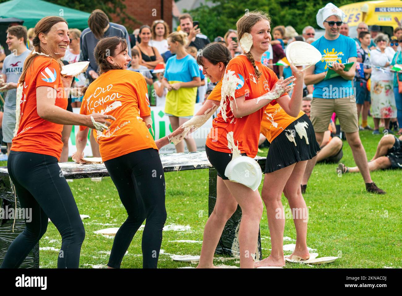 A team of four young women, one spattered with custard, throwing ...