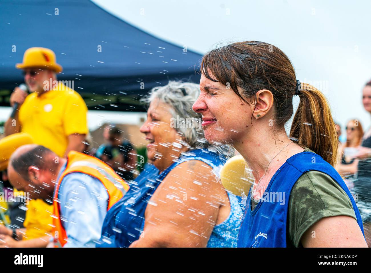 Close up of a woman being hit by a wet sponge on her chin, her eyes ...