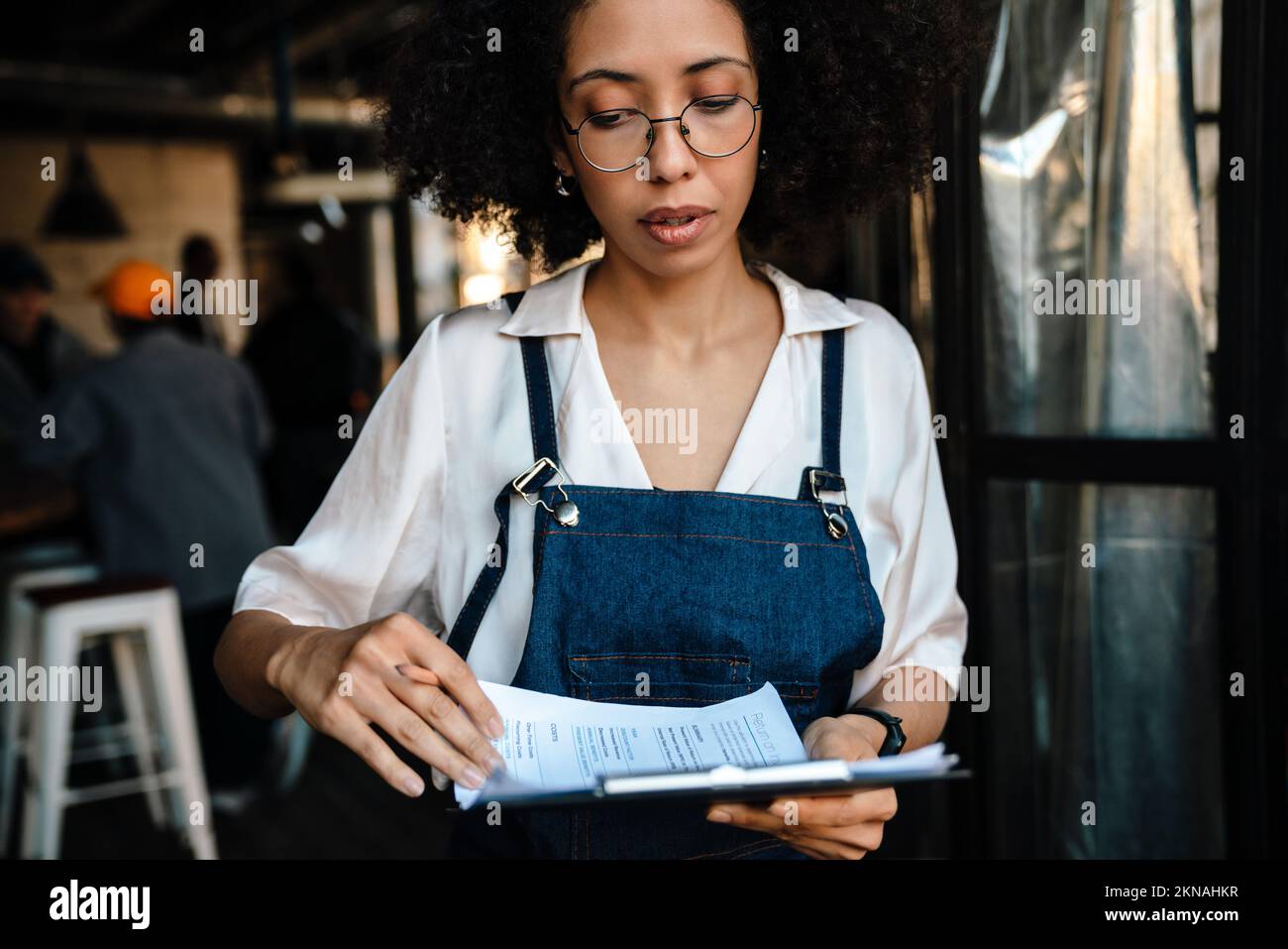 Young african american woman holding clipboard with paper documents ...