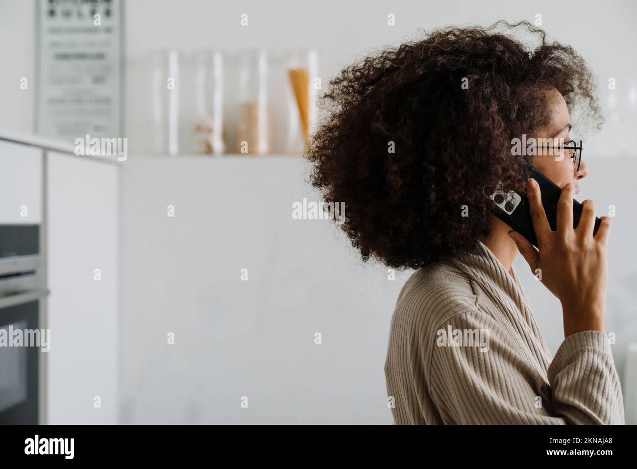 African american young woman with curly hairstyle talking on cellphone ...