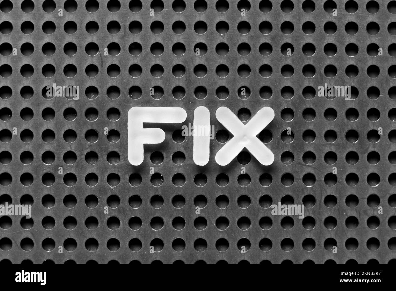 White alphabet letter in word fix on black pegboard background Stock ...