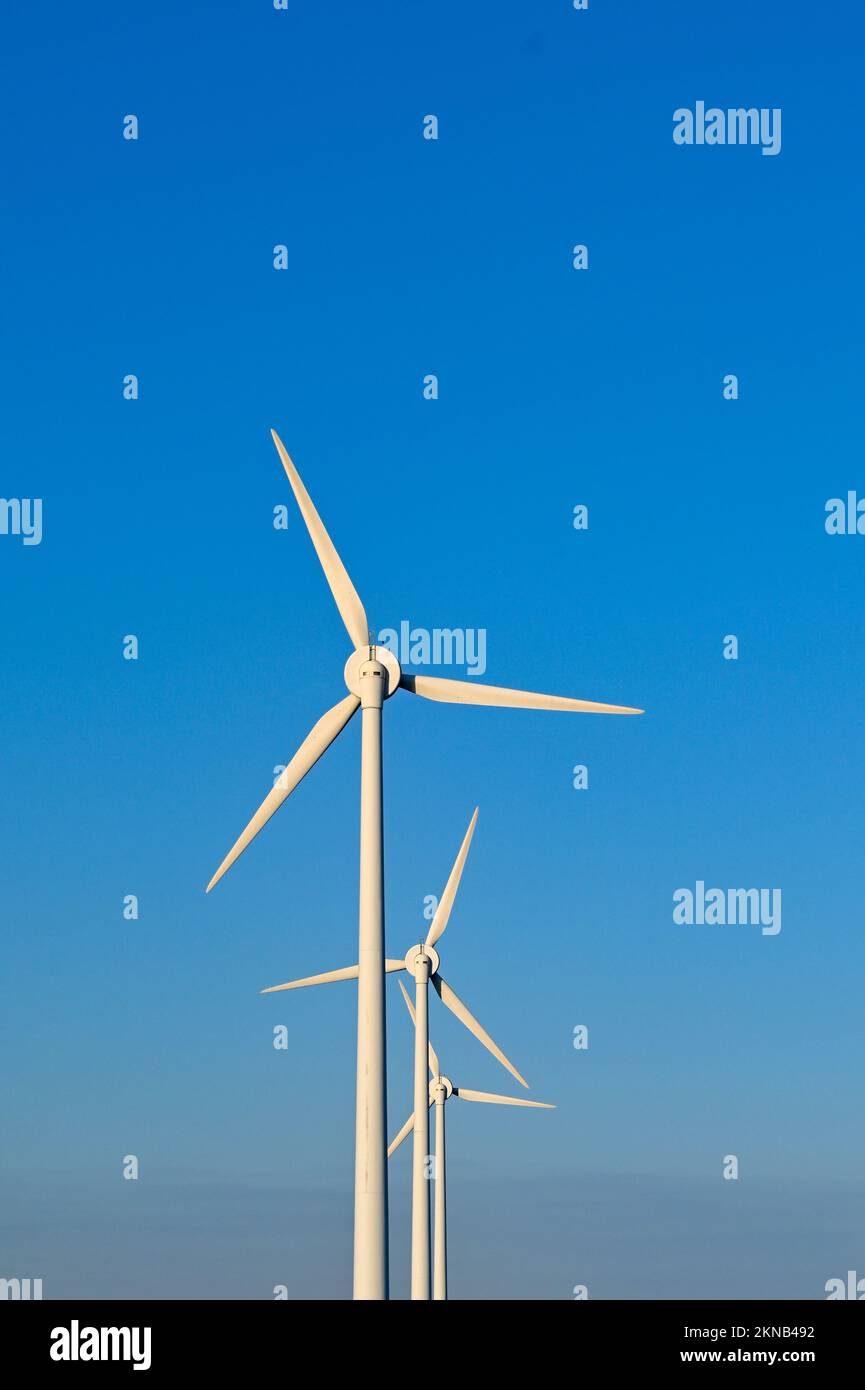 Tall wind turbines isolated against a deep blue sky. No people Stock ...