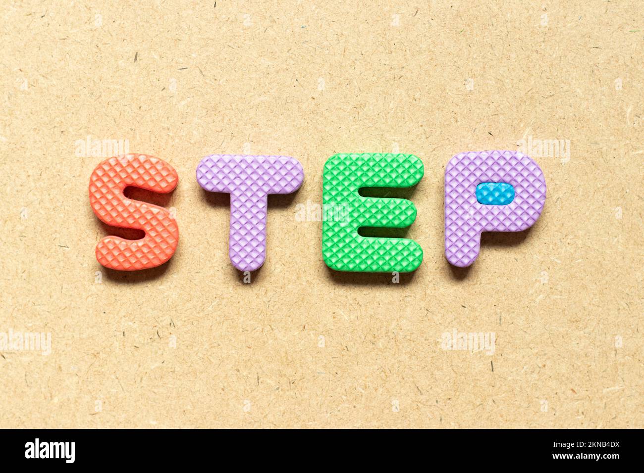 Foam alphabet letter in word step on wood background Stock Photo - Alamy