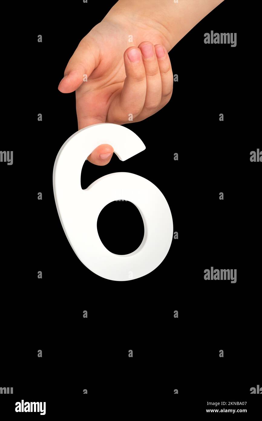 Number six in hand isolated on black background. Number six in a child ...