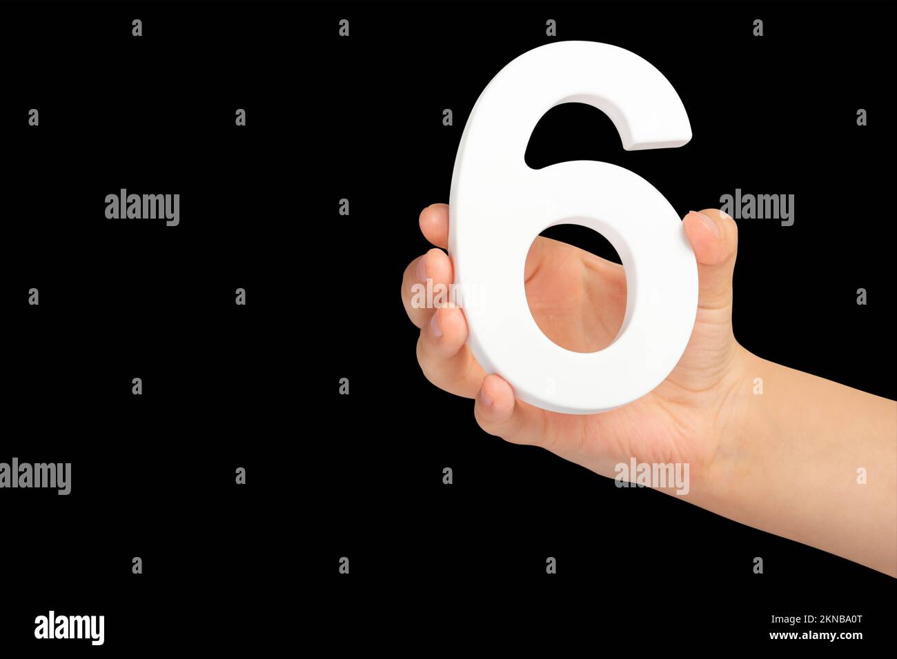 Number six in hand isolated on black background. Number six in a child ...