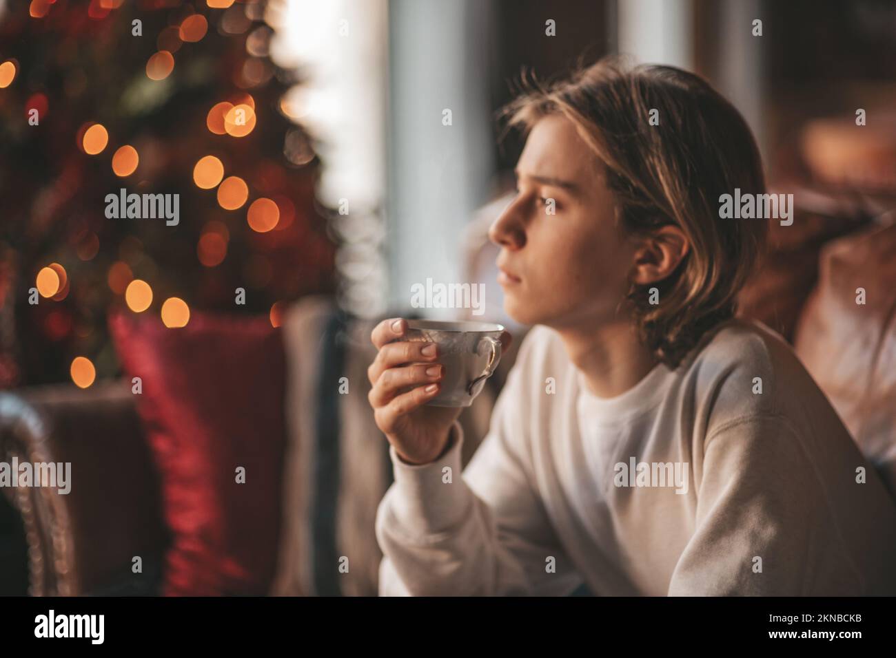 Young teen boy with long hair thoughtful look sad eyes negative mood ...