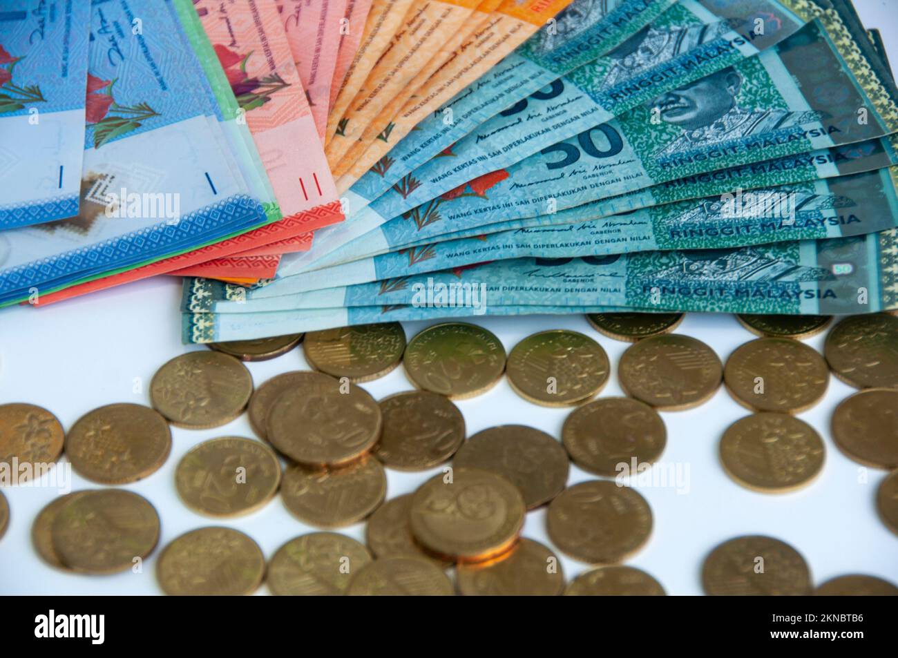 Side view of various Malaysia Ringgit currency and coins on white ...