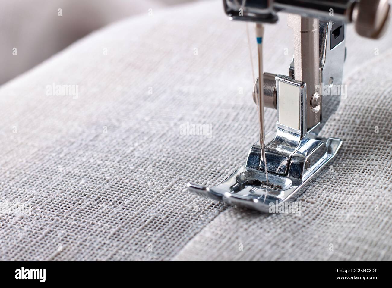 Modern sewing machine presser foot with linen fabric and thread ...
