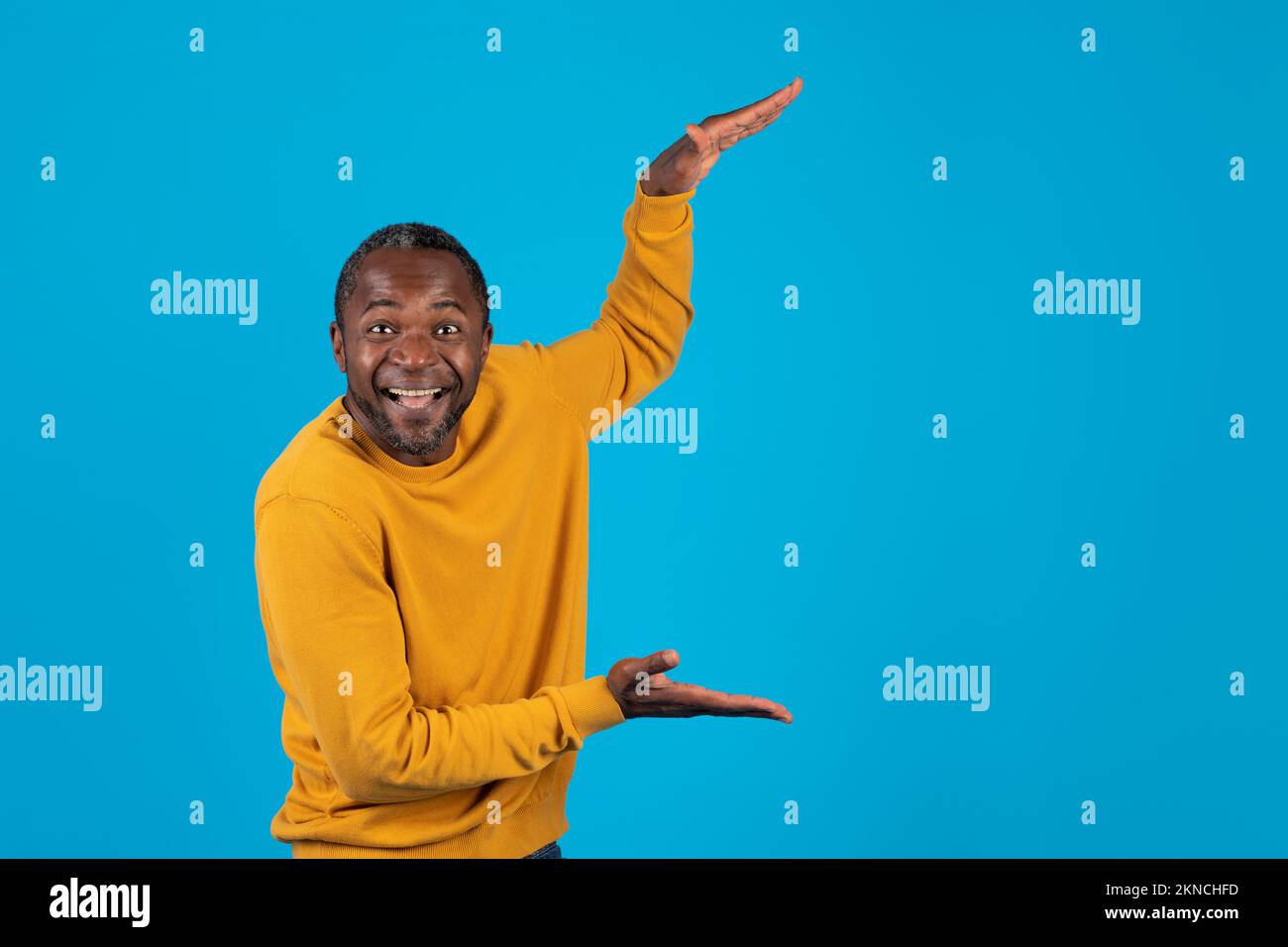 Excited african american man holding something invisible in his hands ...