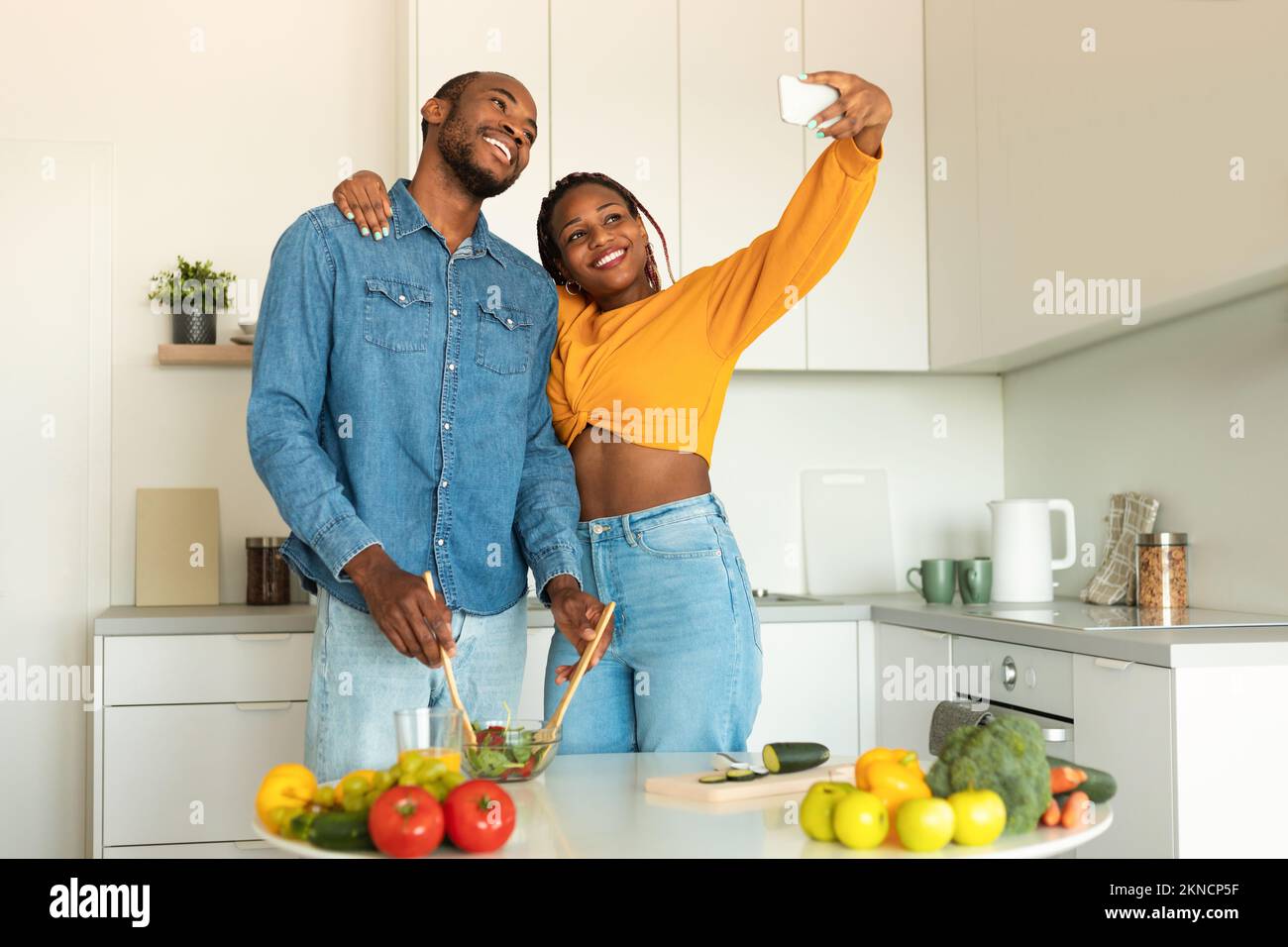 Happy black spouses making selfie while cooking together in kitchen at ...