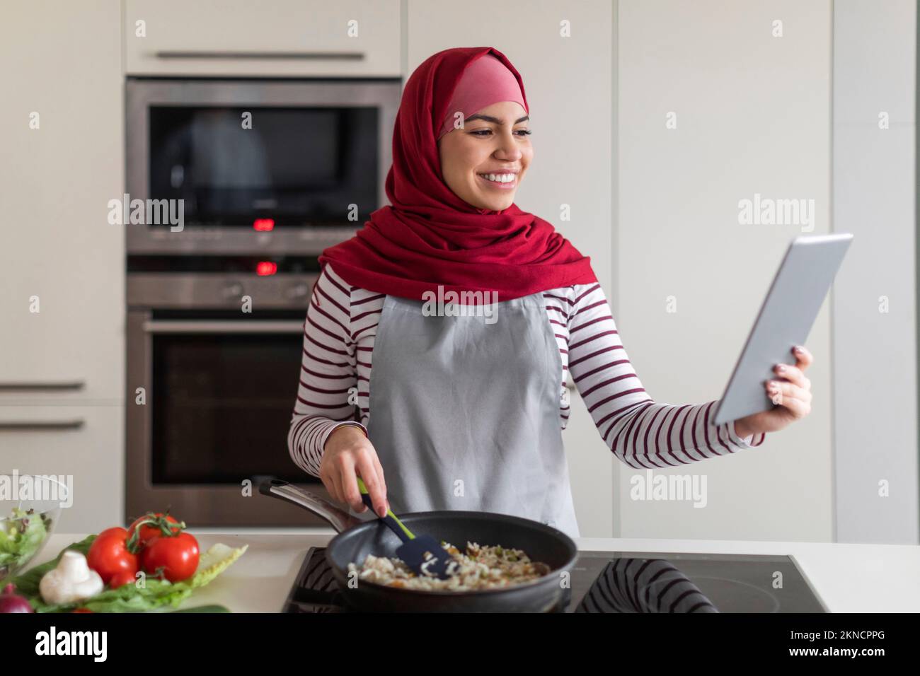 Happy Muslim Woman In Hijab Using Digital Tablet In Kitchen Stock Photo ...