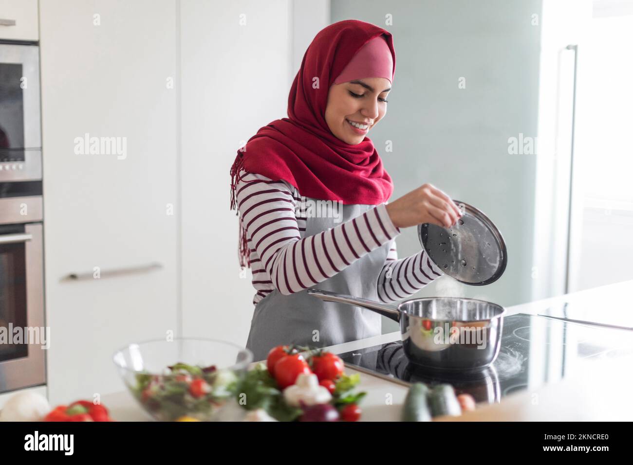 Middle eastern wife cooking rice on stove at kitchen Stock Photo - Alamy