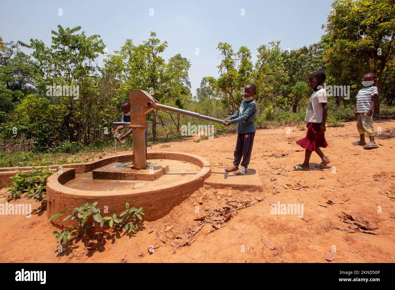 Pupils drinking water in the community hand water pump in Africa Stock ...