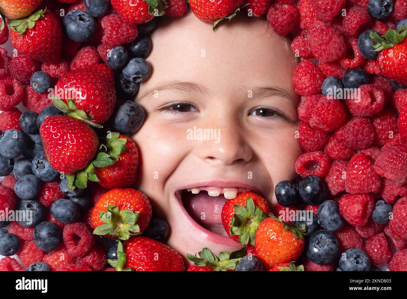 Vitamins from berrie. Mix of berries. Kids face with fresh berries ...