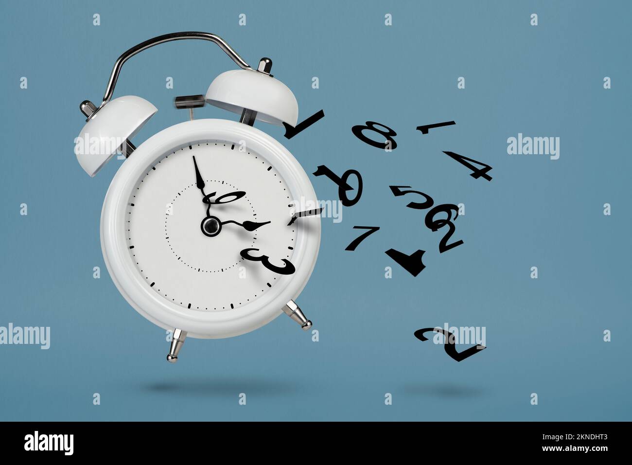 Time is running out. White alarm clock with flying numbers as a symbol ...