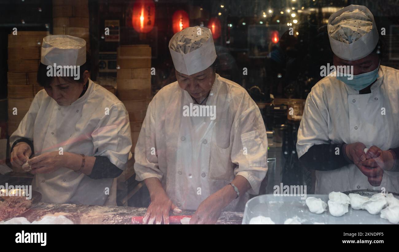 Three chefs prepare food at the Beijing Dumpling restaurant in London ...