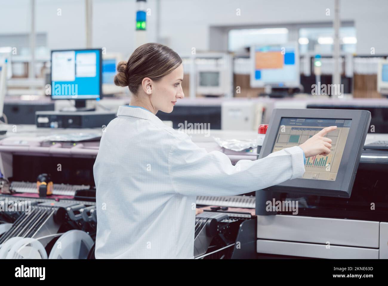 Woman on control compute of assembly line Stock Photo - Alamy