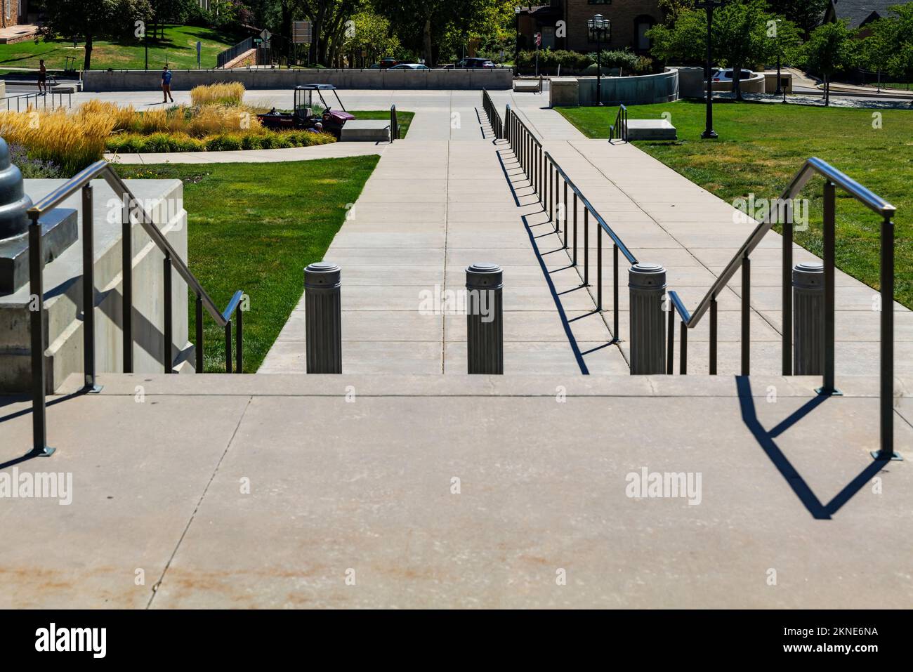 Metal railings at the marble steps on a front of a grass field in a ...