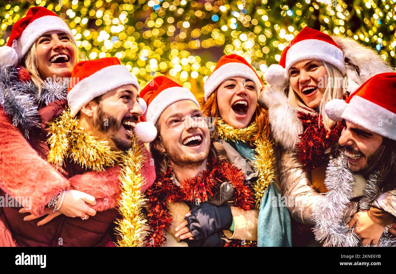 Young friends walking with santa hats at winter travel location on ...