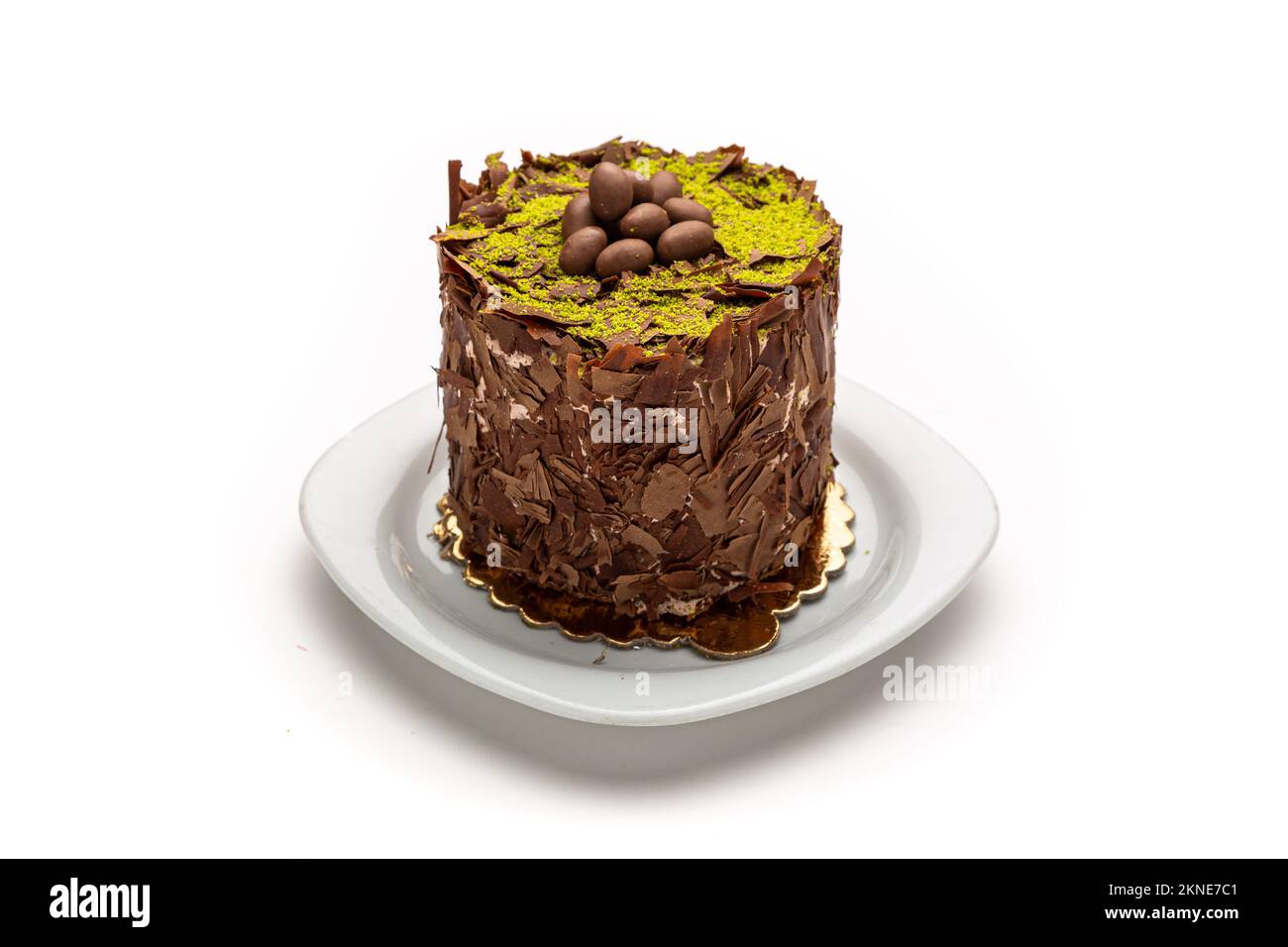 An isolated shot of a plate of chocolate cake with nut toppings on a ...