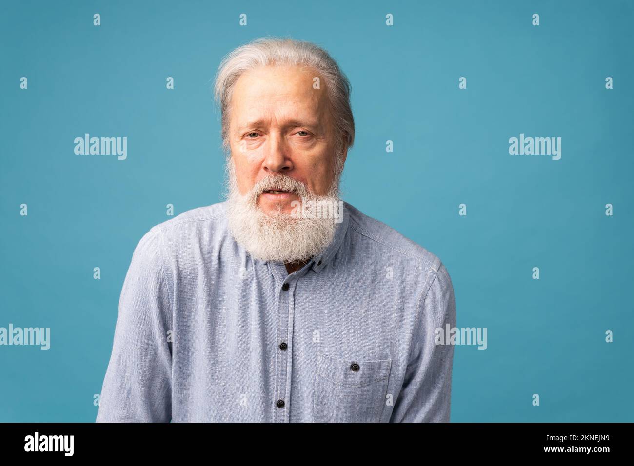 Portrait of unhappy grumpy pissed off senior mature man on blue ...
