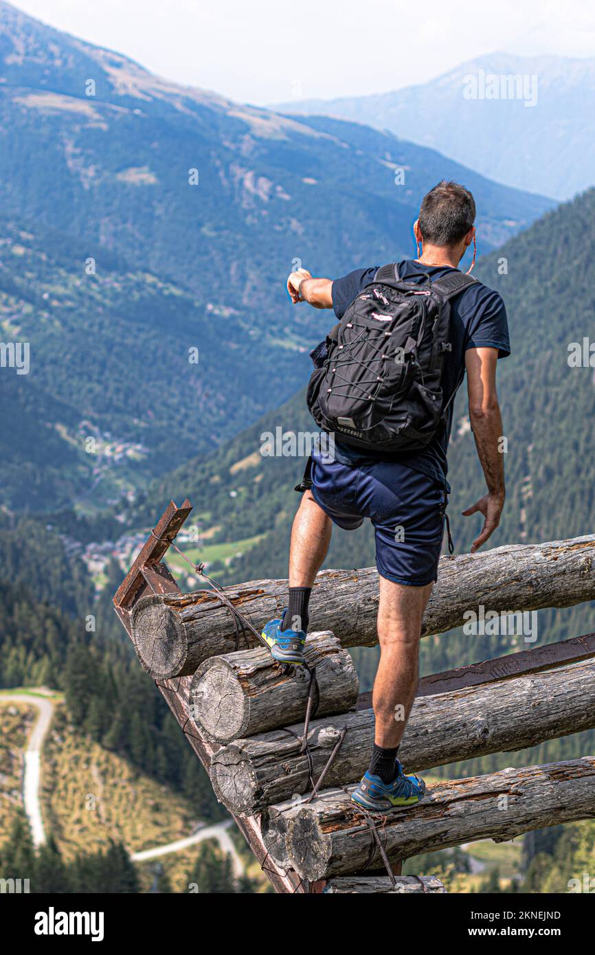 A vertical shot of a man standing on a wooden observing deck ...