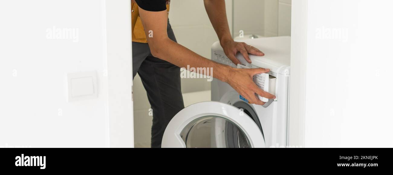 Young attractive smiling worker in uniform fixing washing machine Stock ...