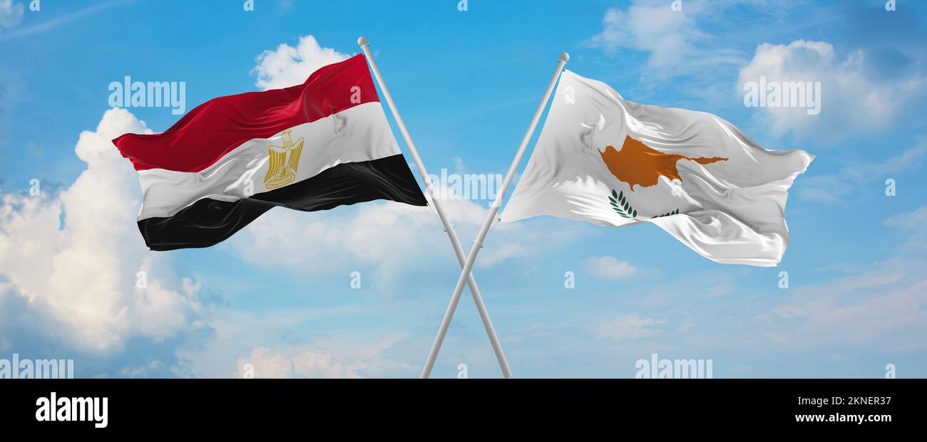 two crossed flags Cyprus and Egypt waving in wind at cloudy sky ...