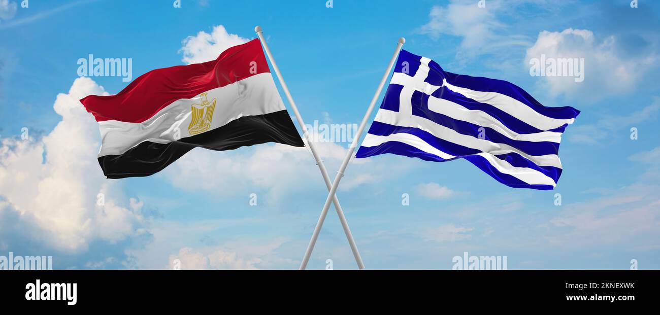 two crossed flags Greece and Egypt waving in wind at cloudy sky ...
