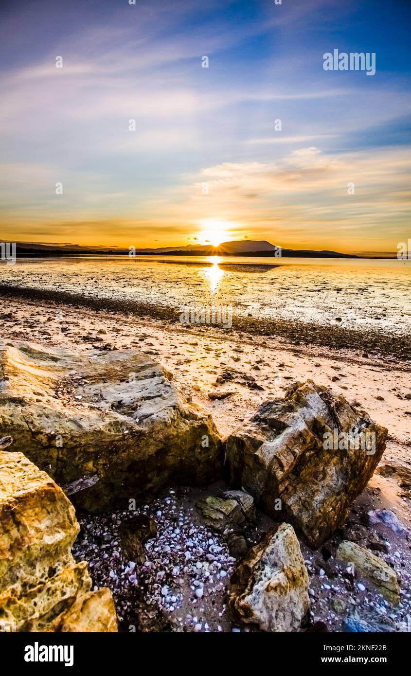 Sun setting on a gorgeous and remote Tasmania beach with shell covered ...