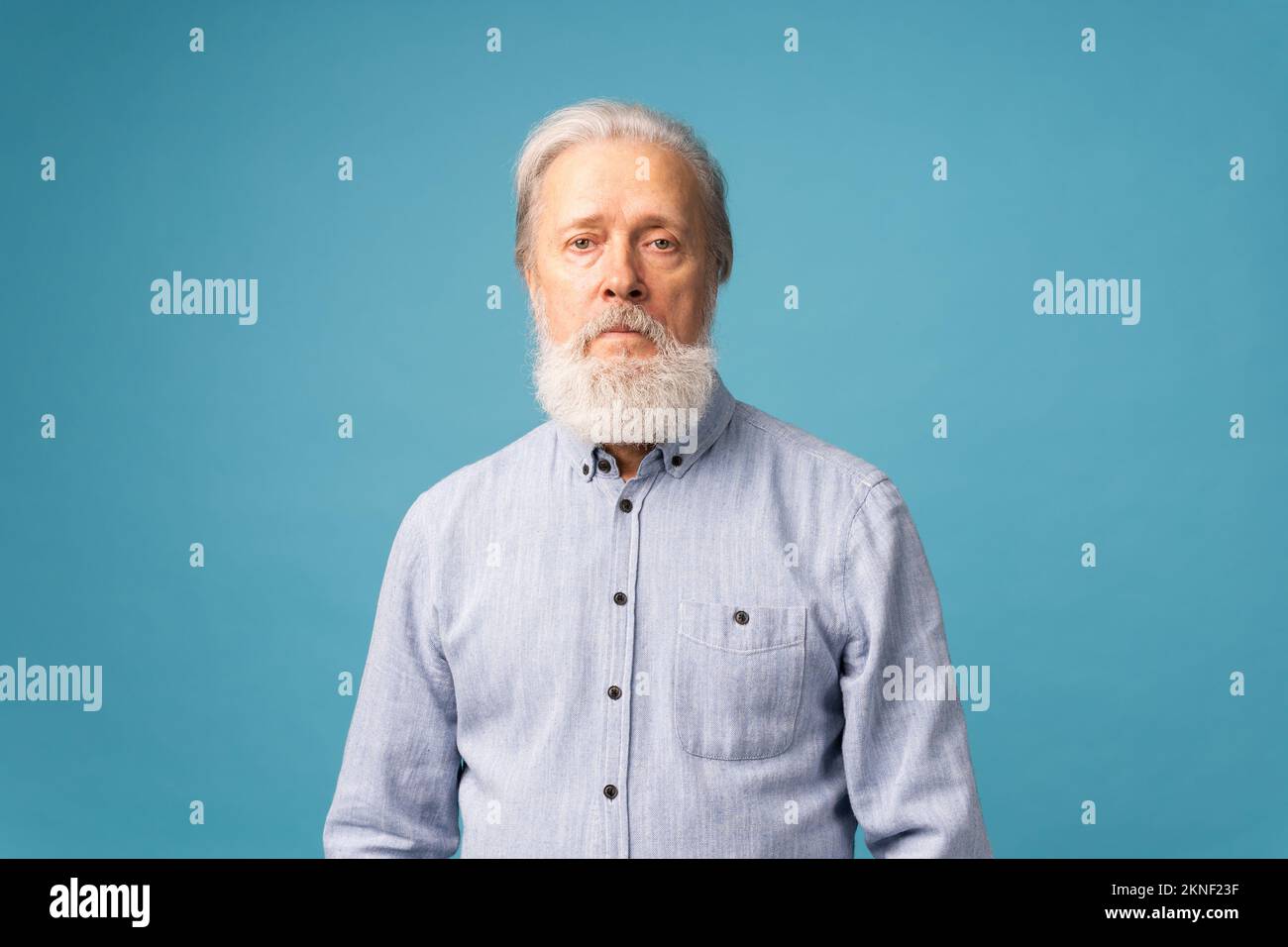 Portrait of unhappy grumpy pissed off senior mature man on blue ...